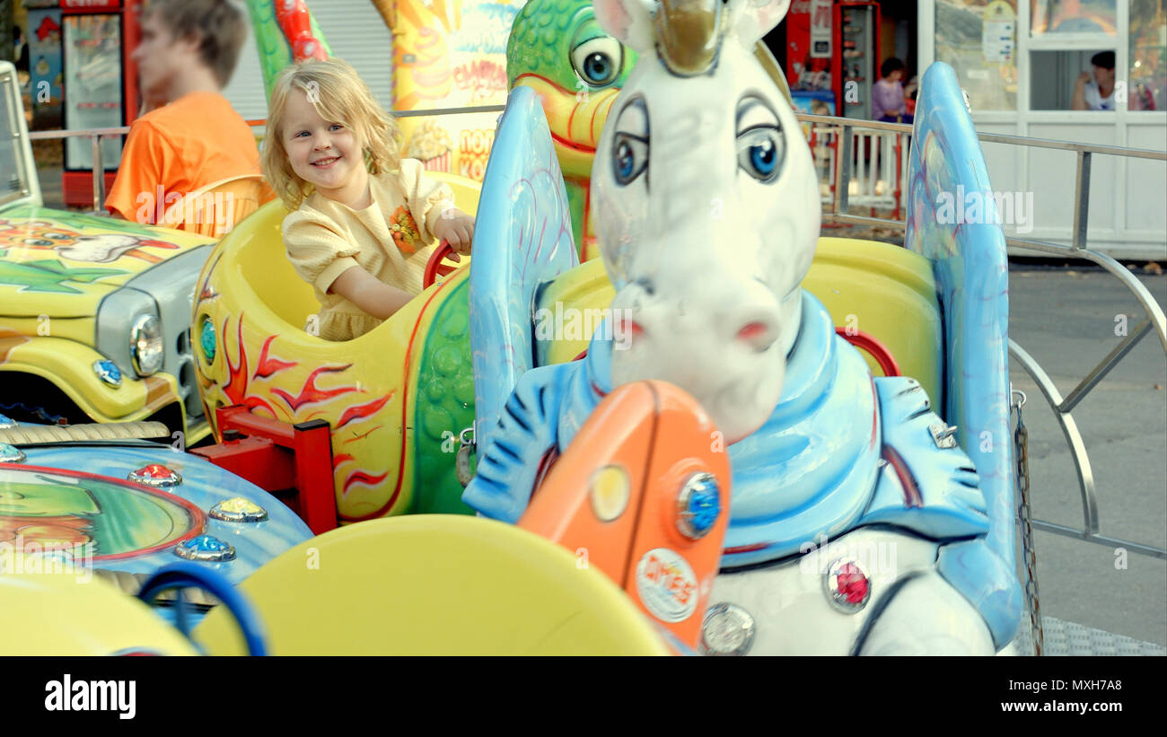 Girl riding a colorful carousel Stock Photo - Alamy