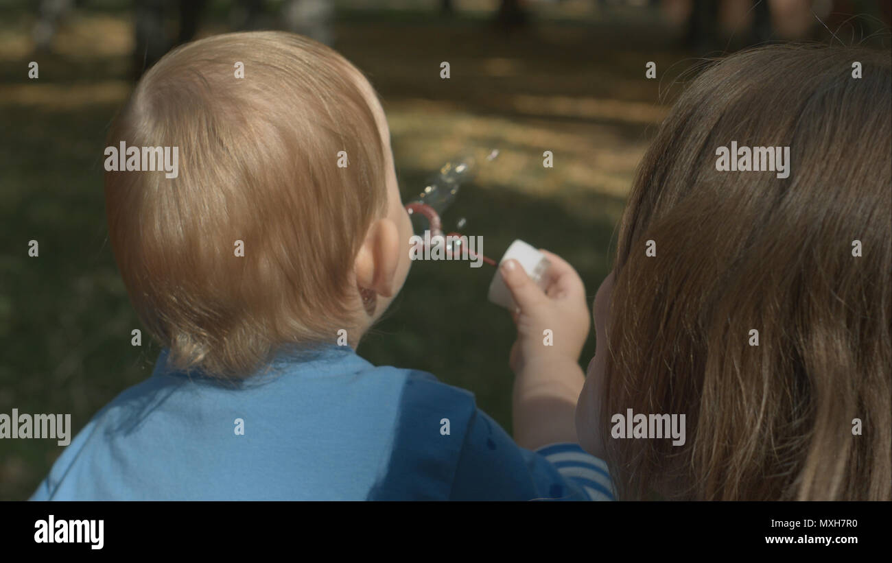 Cute boy blowing soap bubbles. Back view Stock Photo - Alamy