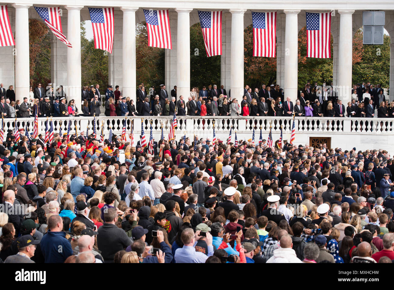Visitors to Arlington National Cemetery listen to remarks during the ...