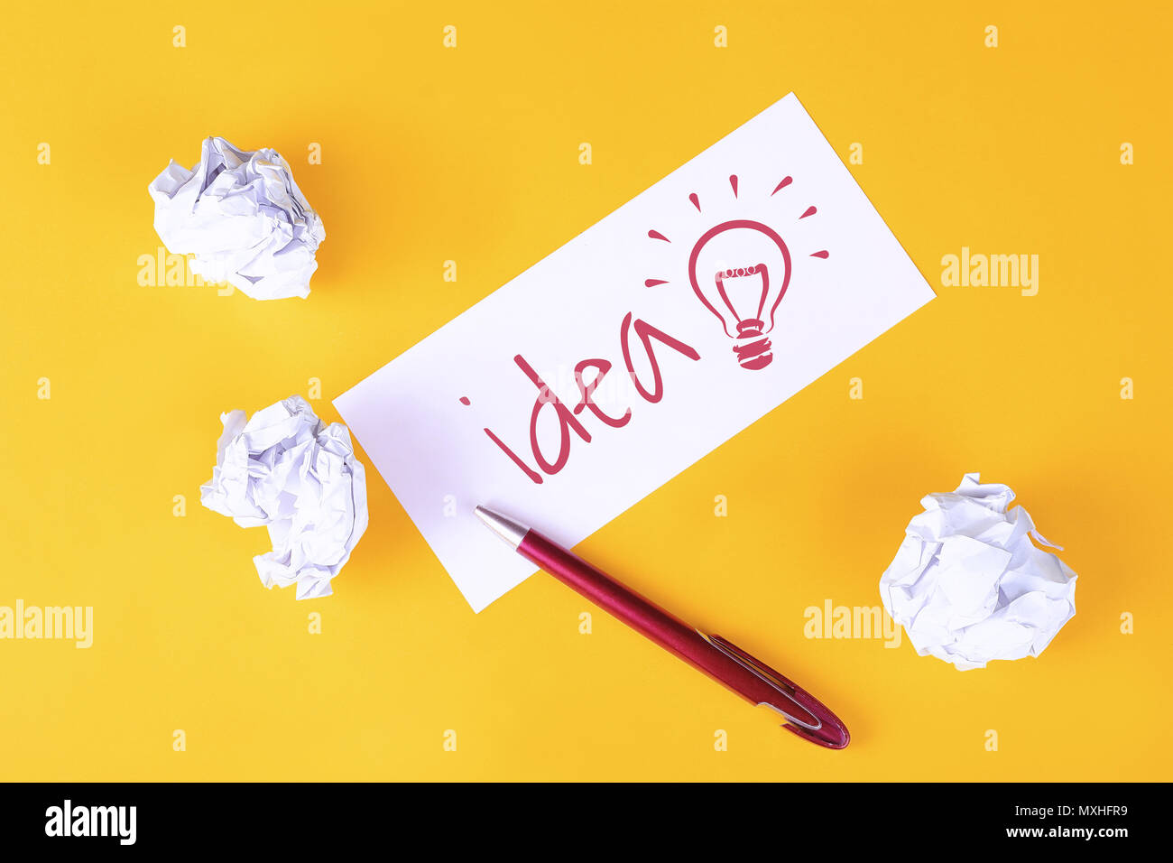 Paper with "idea" text and crumpled paper balls on yellow background ...