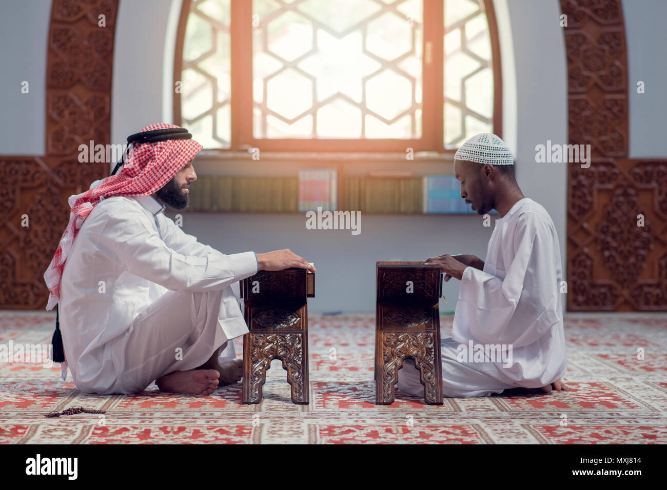 Two muslim men reading Koran in the mosque Stock Photo - Alamy