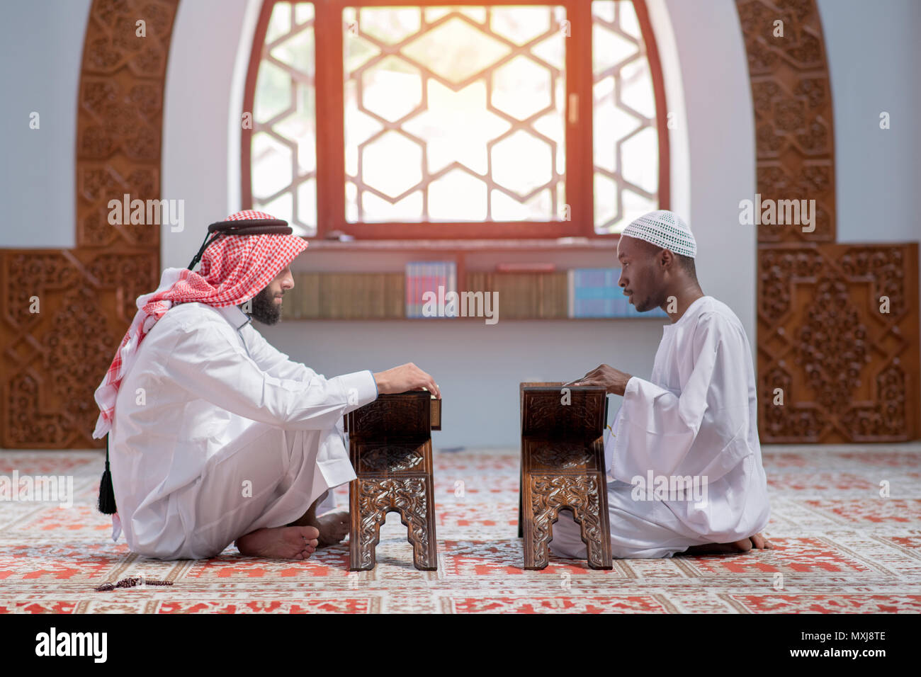 Two muslim men reading Koran in the mosque Stock Photo - Alamy