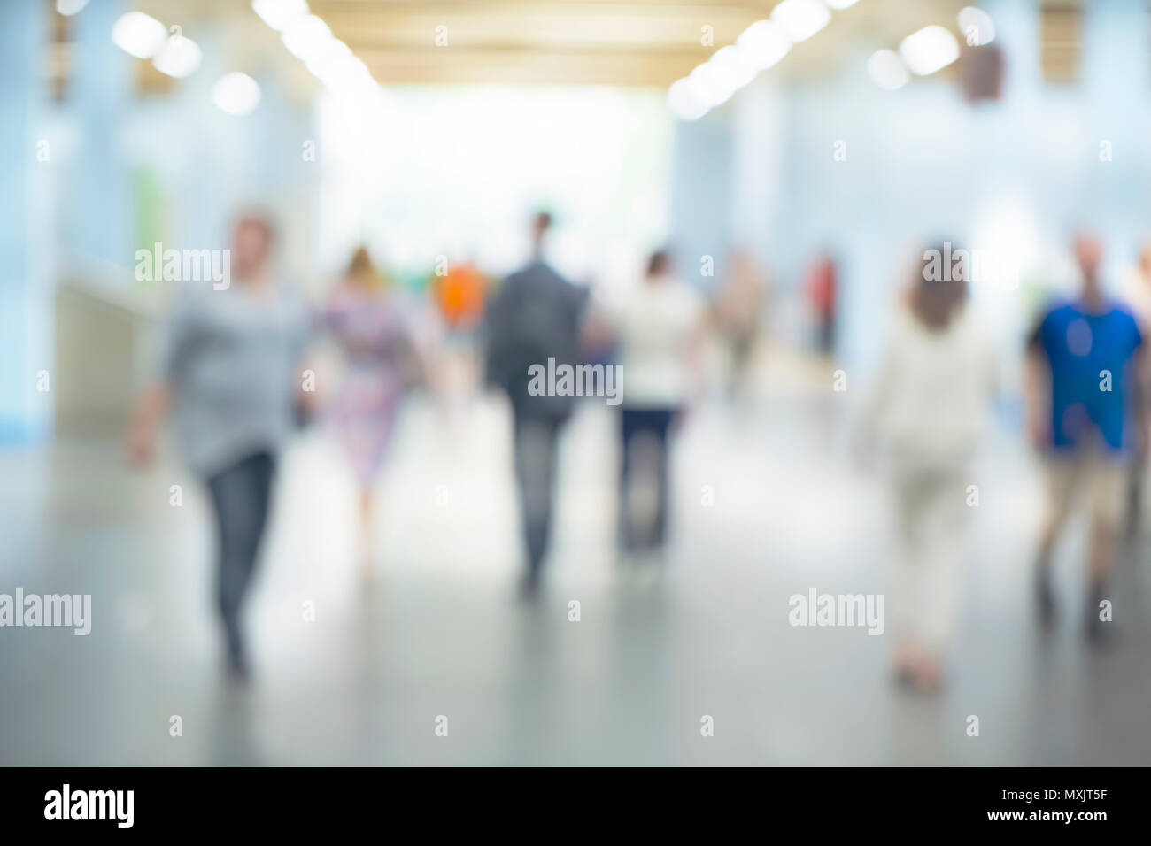 silhouettes of people as they move through the mal with light ...