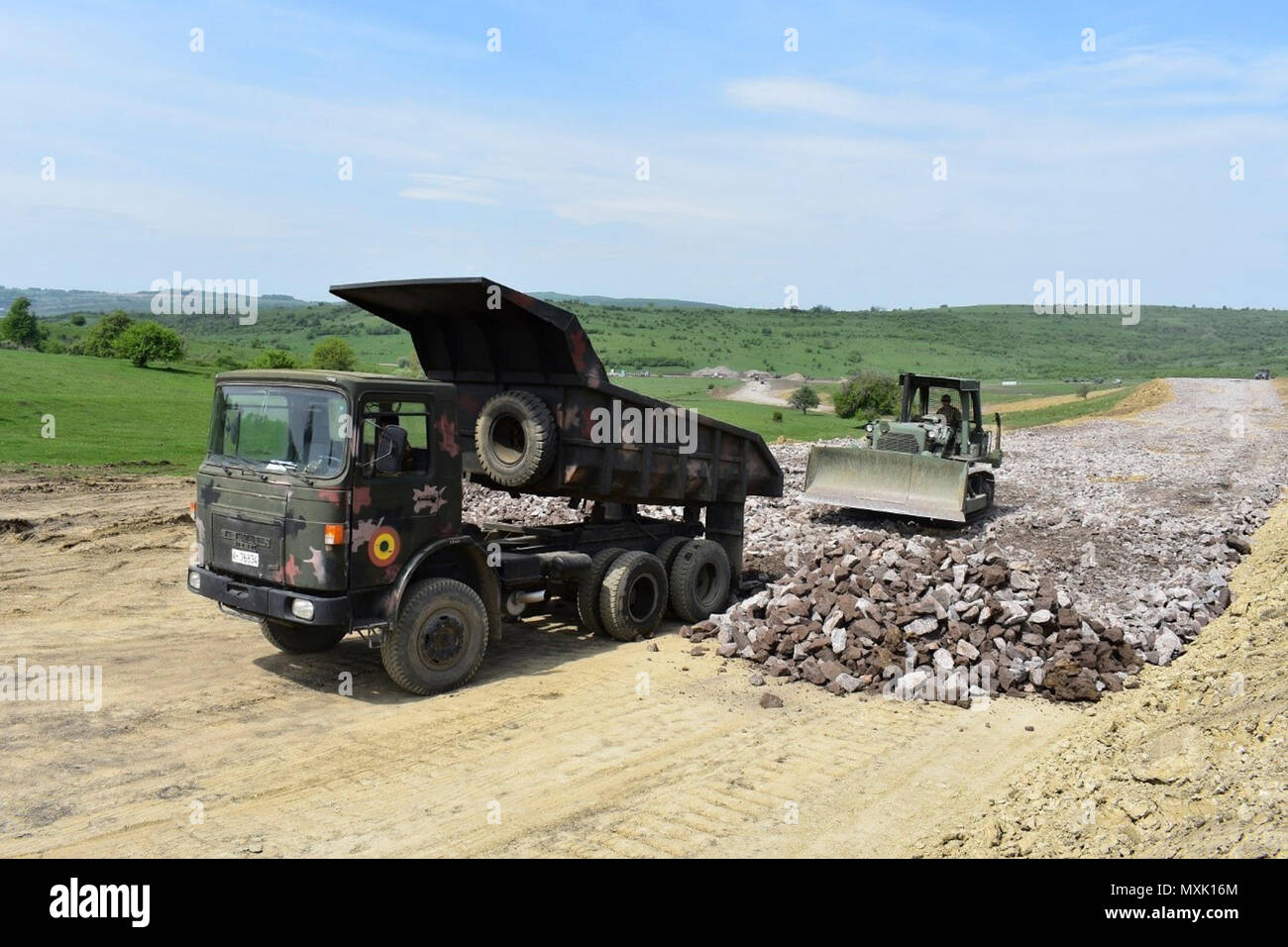 A soldier of the 10th Romanian Engineer Brigade places rock for a road ...