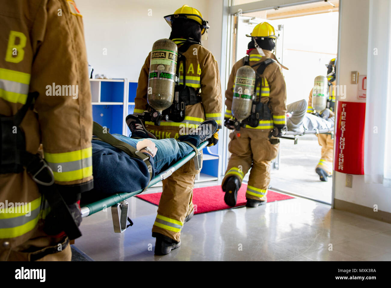 Firefighters from the 374th Civil Engineer Squadron carry victims of a ...