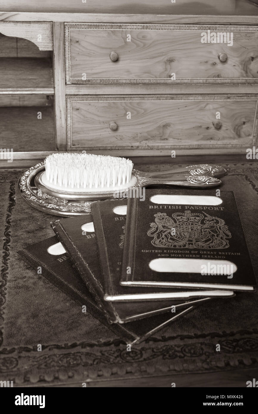 antique desk with passports and silver hairbrush and mirror in sepia ...