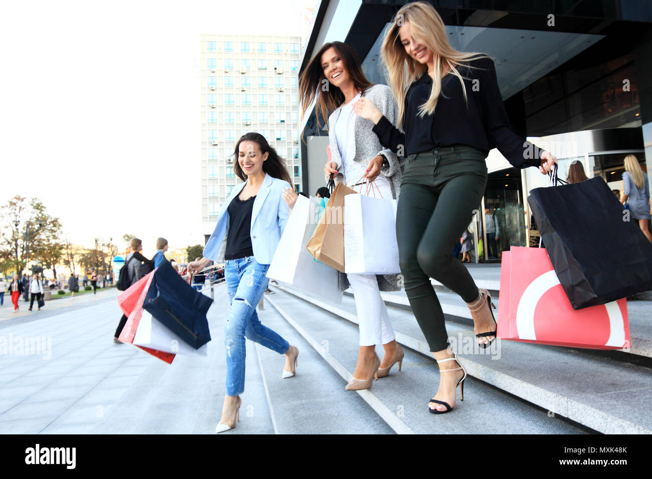 Shopping Concept - Beautiful girls with shopping bags walking at the ...