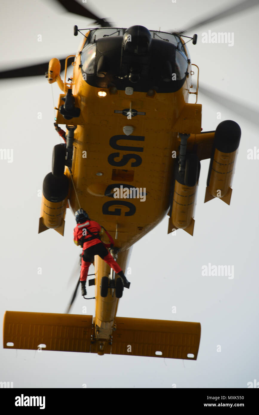 An aviation survival technician deploys from an MH-60 Jayhawk ...