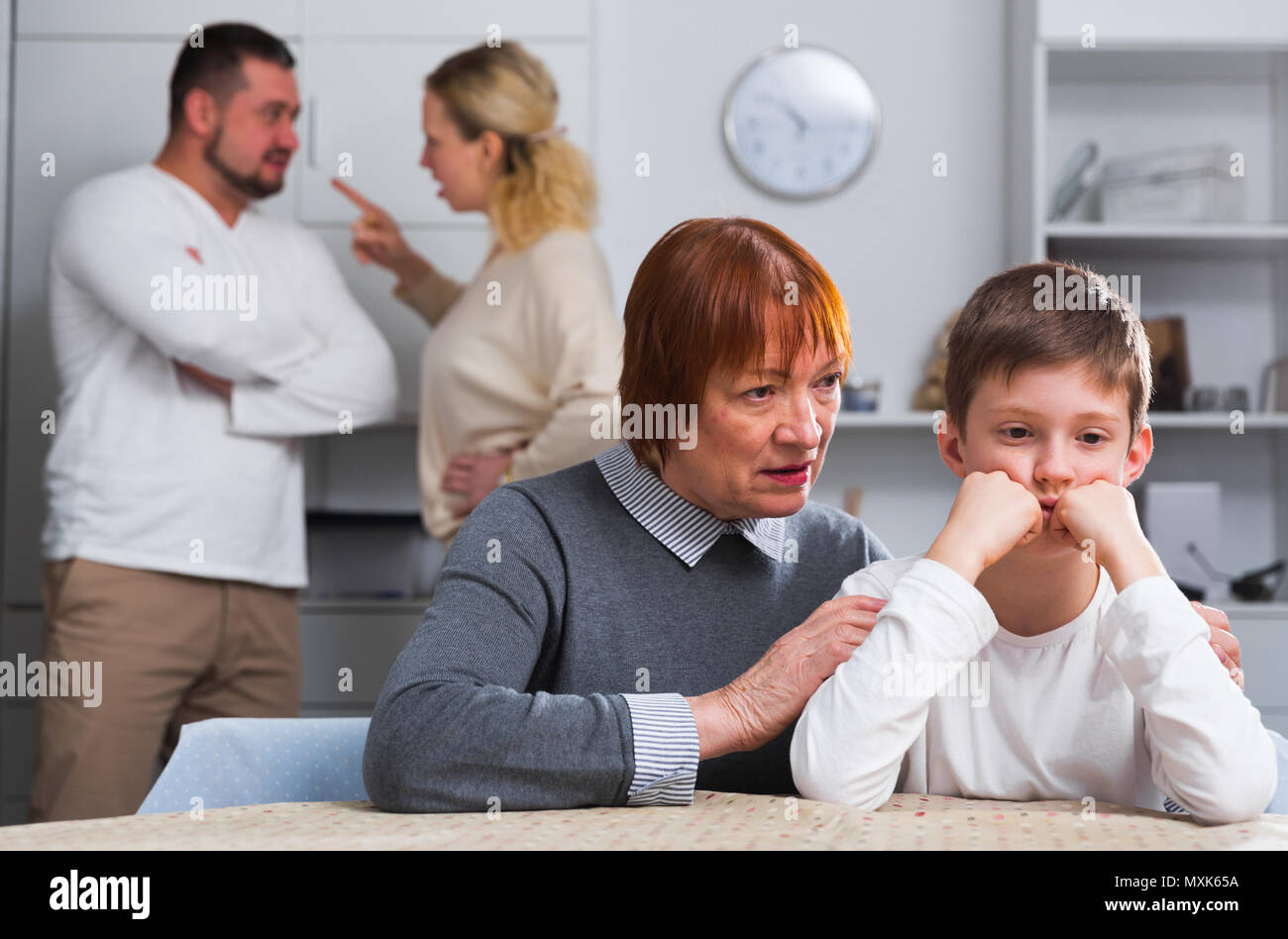 Senior woman calming chagrined boy during his parents quarrel Stock ...