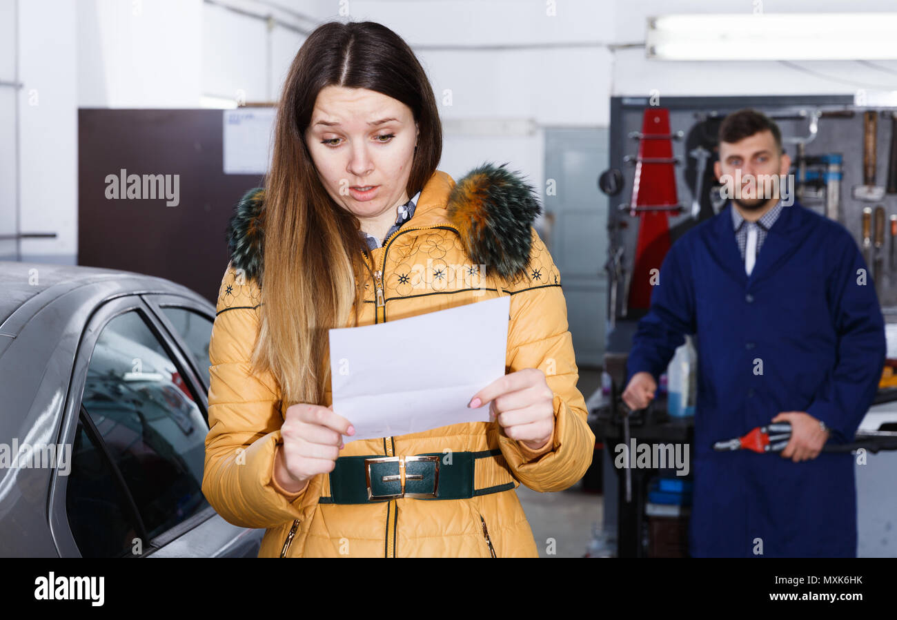 Woman client is dissatisfied of repair of her car in winter in workshop ...