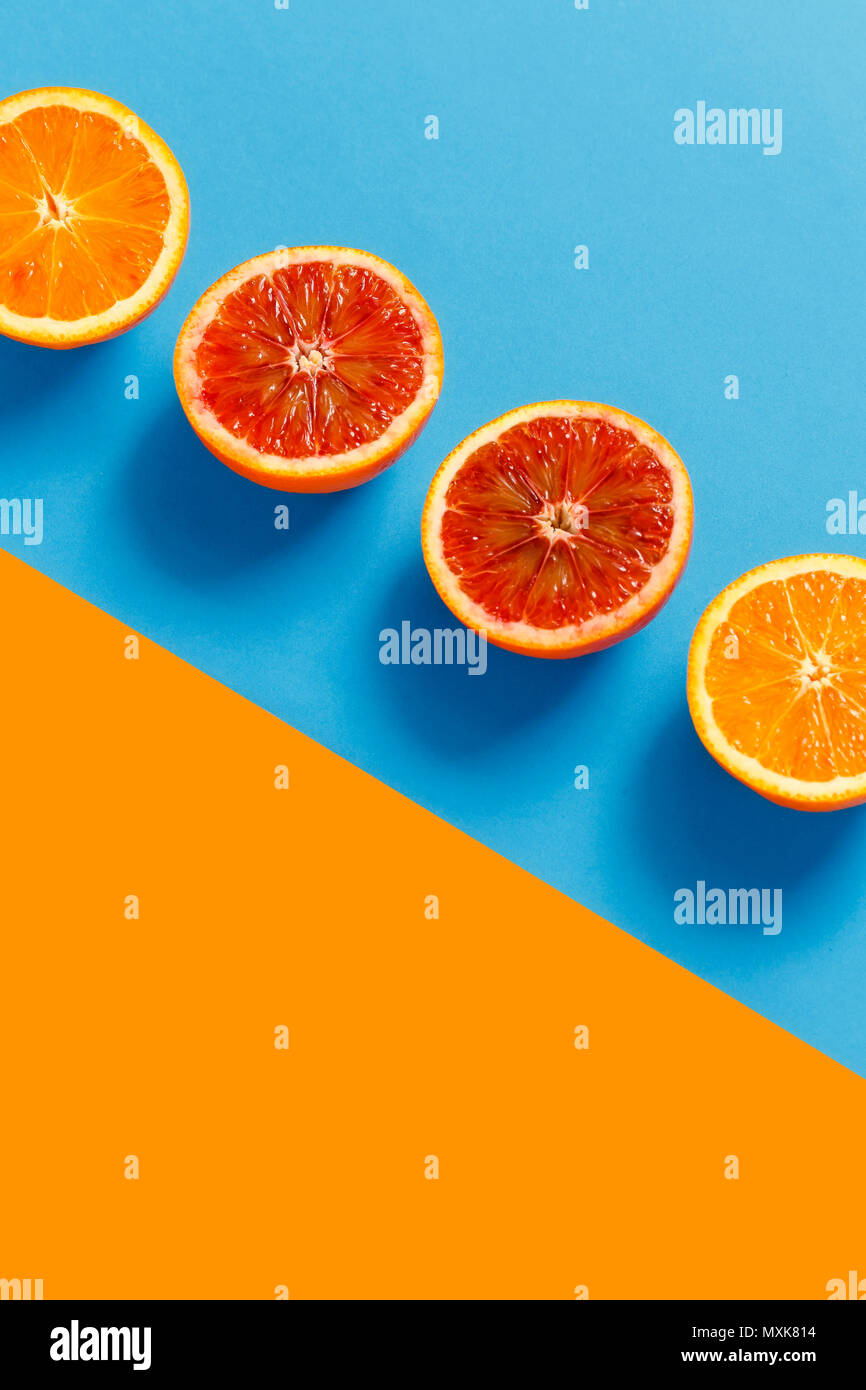 Oranges cut in half on a orange and blue background. Complementary ...