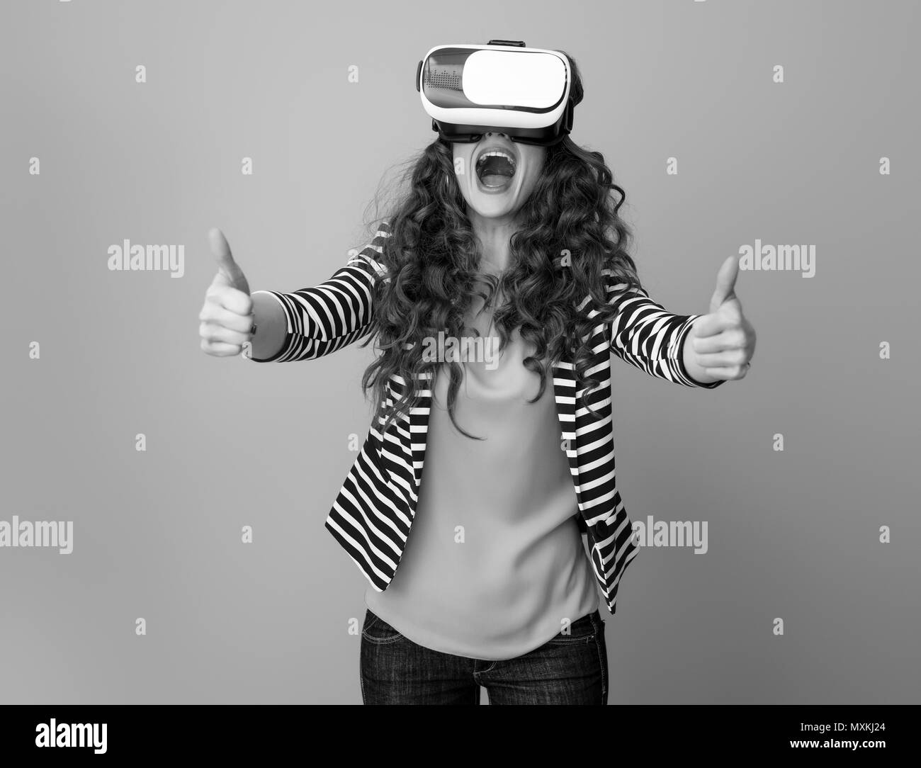 cheerful modern woman with long wavy brunette hair in virtual reality ...