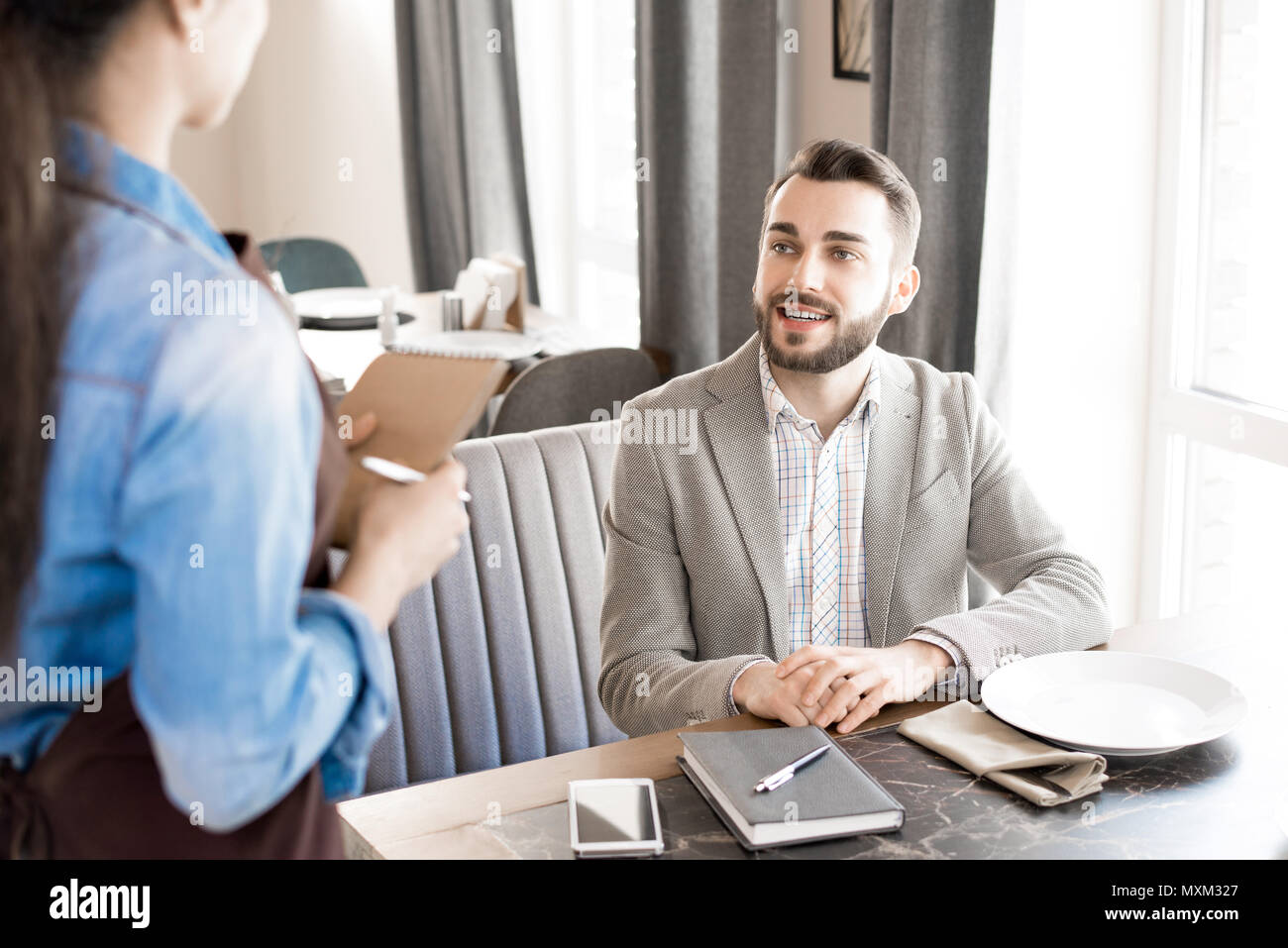 Positive businessman making order in restaurant Stock Photo - Alamy
