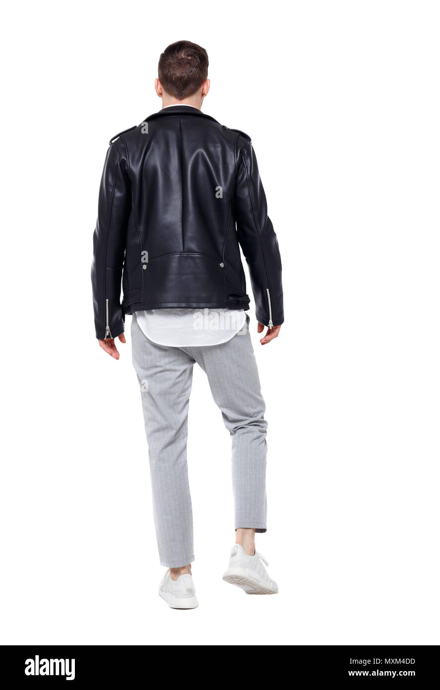 Back view of going handsome man in a leather jacket and trousers ...