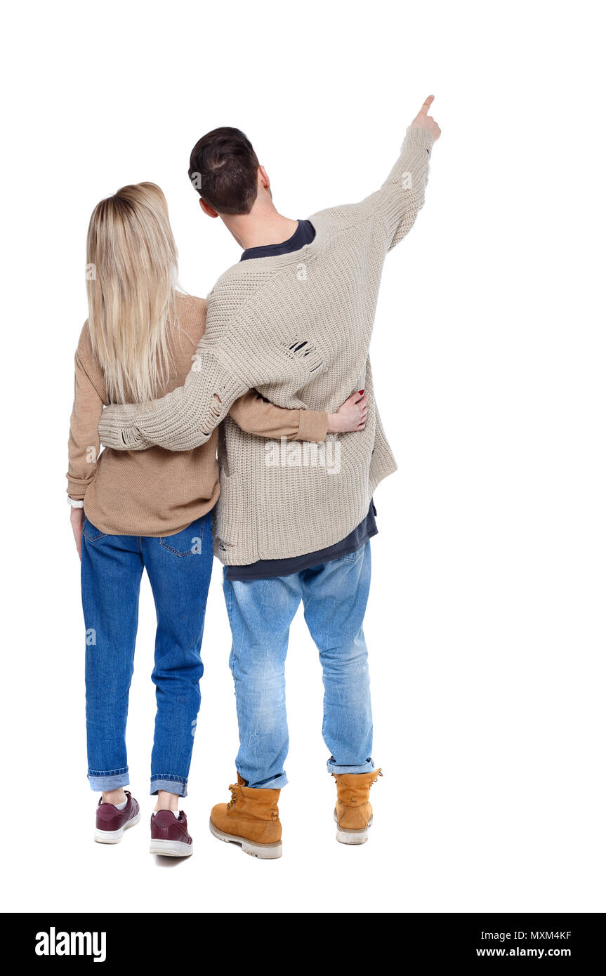 Back view of a heterosexual couple who hugs and points out. Rear view ...