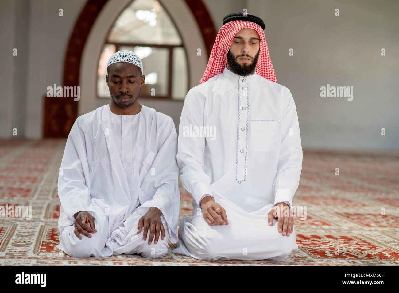 Two religious muslim man praying together inside the mosque Stock Photo ...