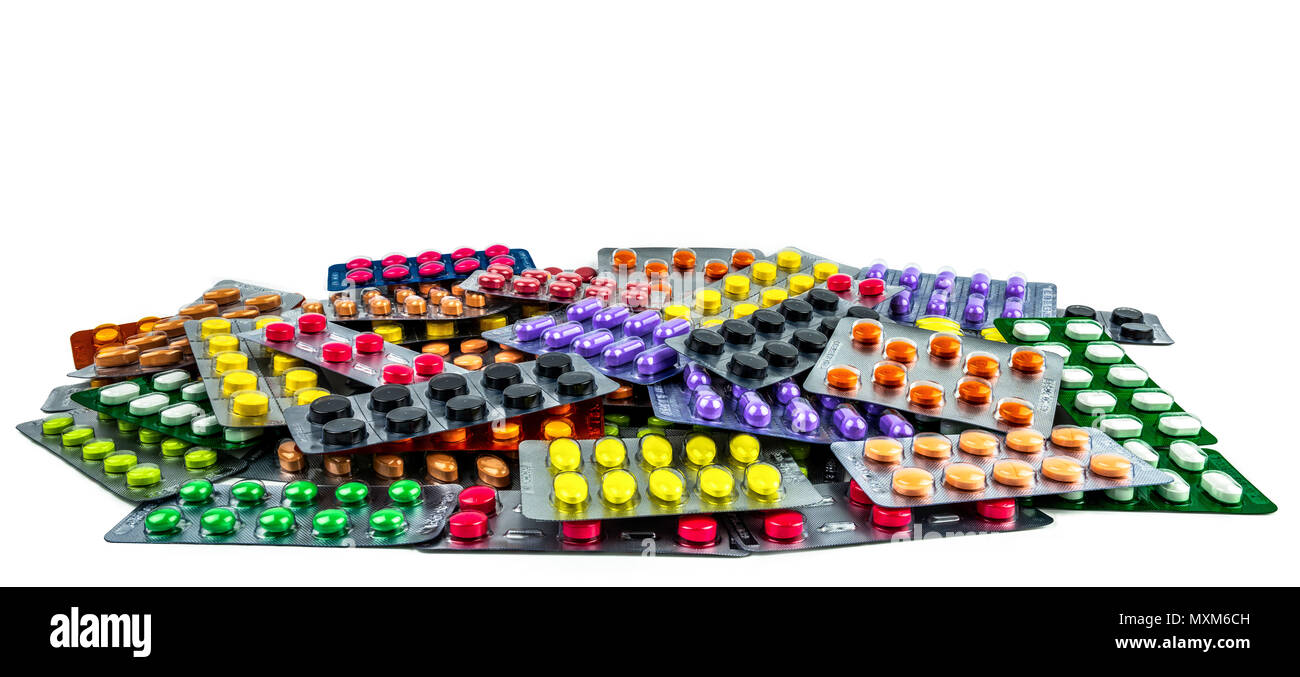 Pile of tablet pills isolated on white background. Yellow, purple ...