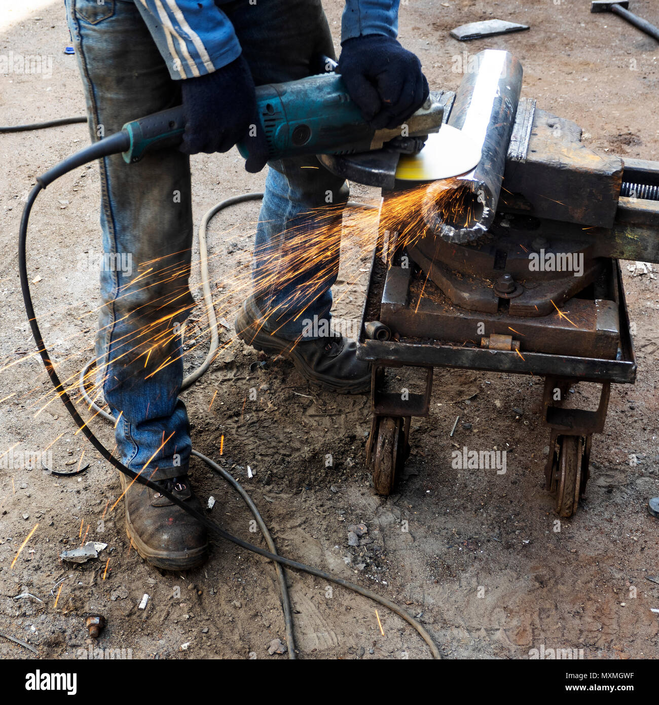 Metal work. Man grinds a steel piece with an angle grinder Stock Photo ...