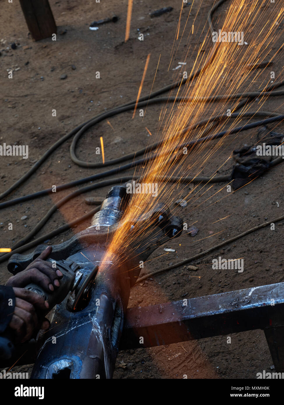 Metal work. Man grinds a steel piece with an angle grinder Stock Photo ...