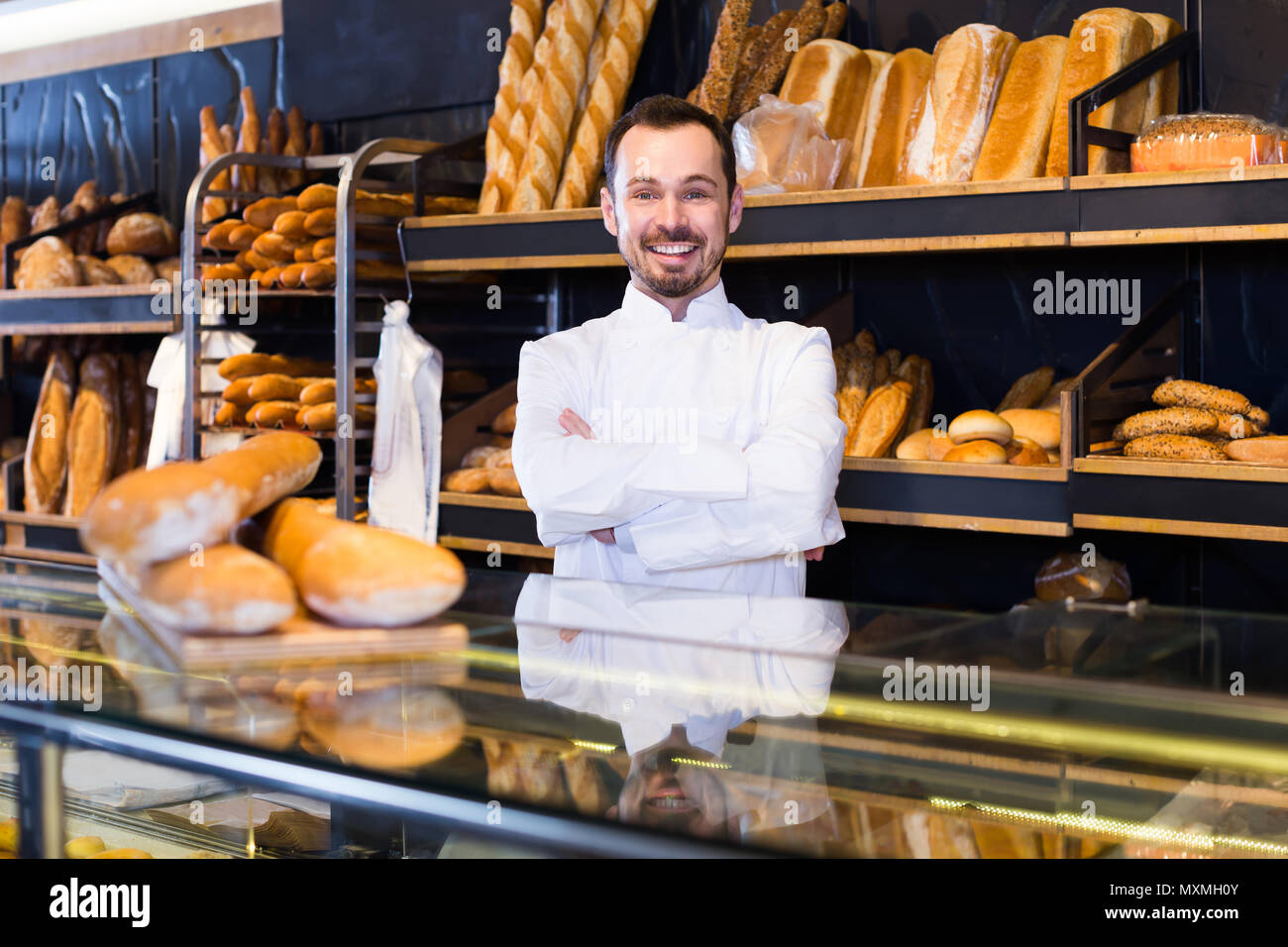Smiling male pastry maker demonstrating pastry in bakery Stock Photo ...