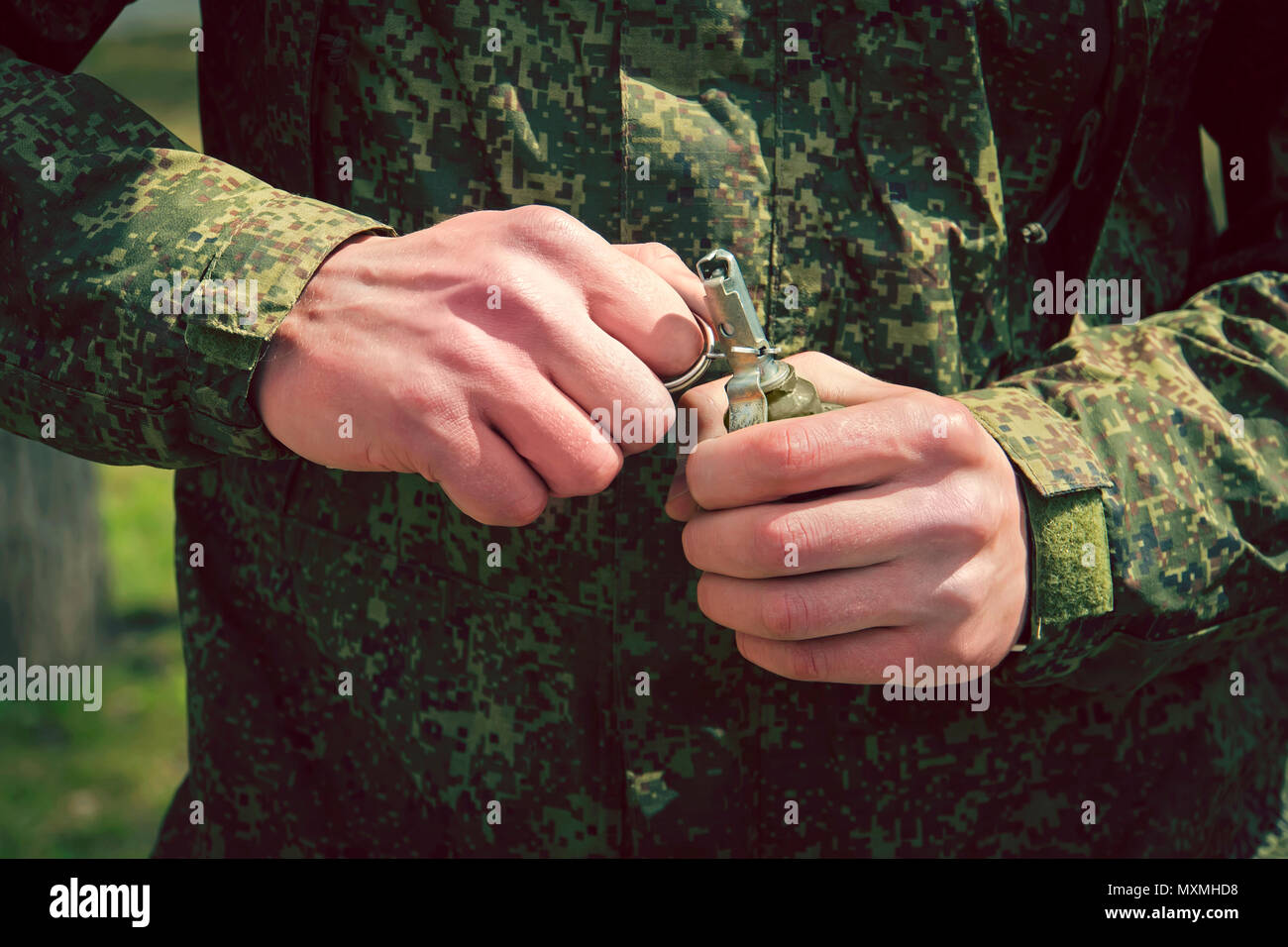 Soldier in camouflage hold the fragmentation grenade. Self-explosion ...