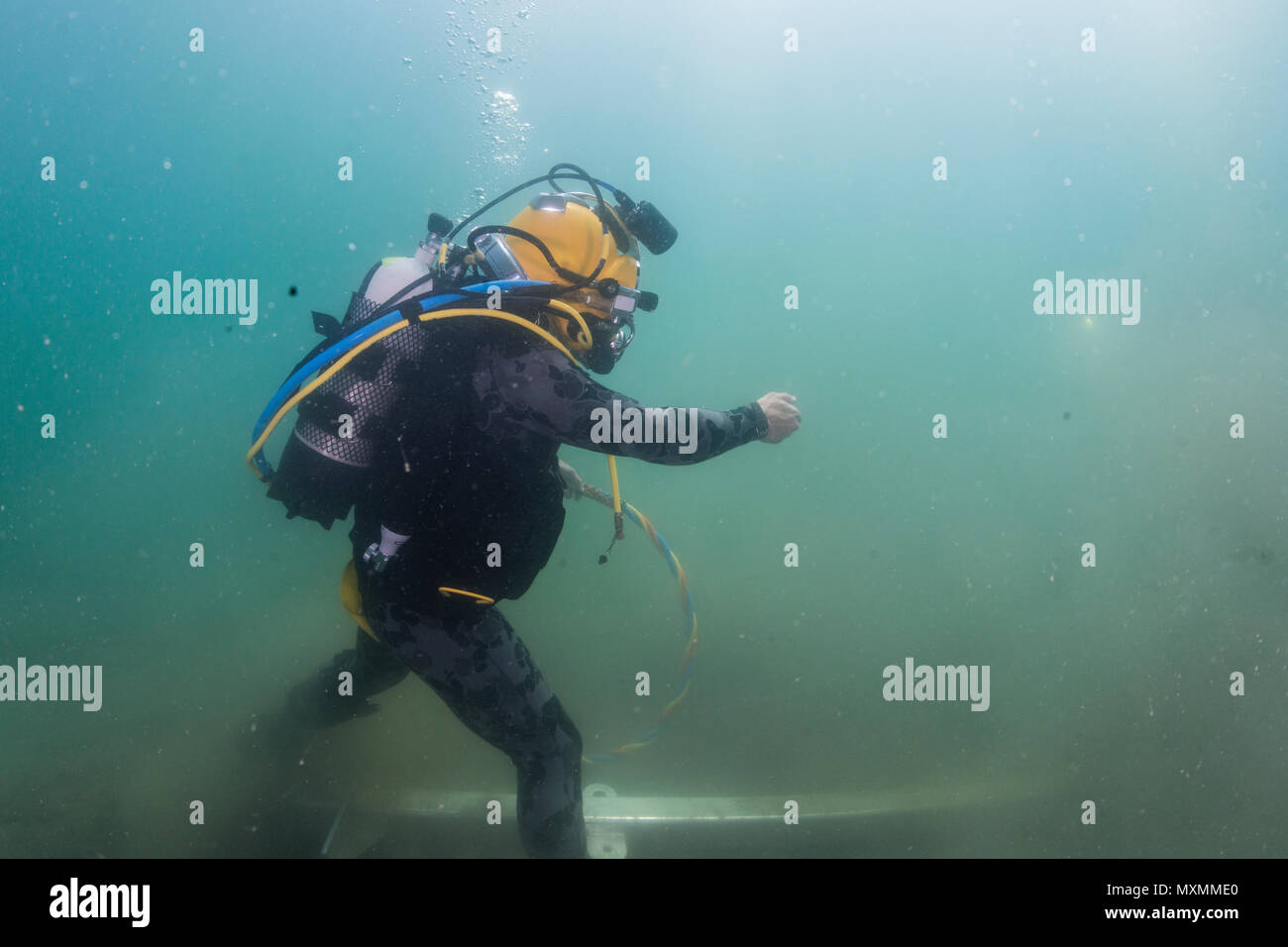 A Royal Australian Navy Diver conducts underwater salvage operations ...