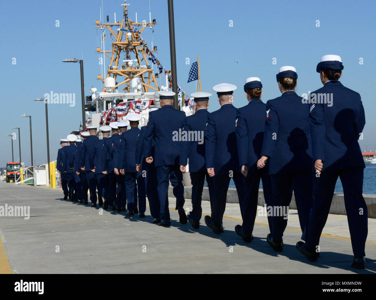 Members of the Coast Guard Cutter Rollin Fritch walk toward their ...