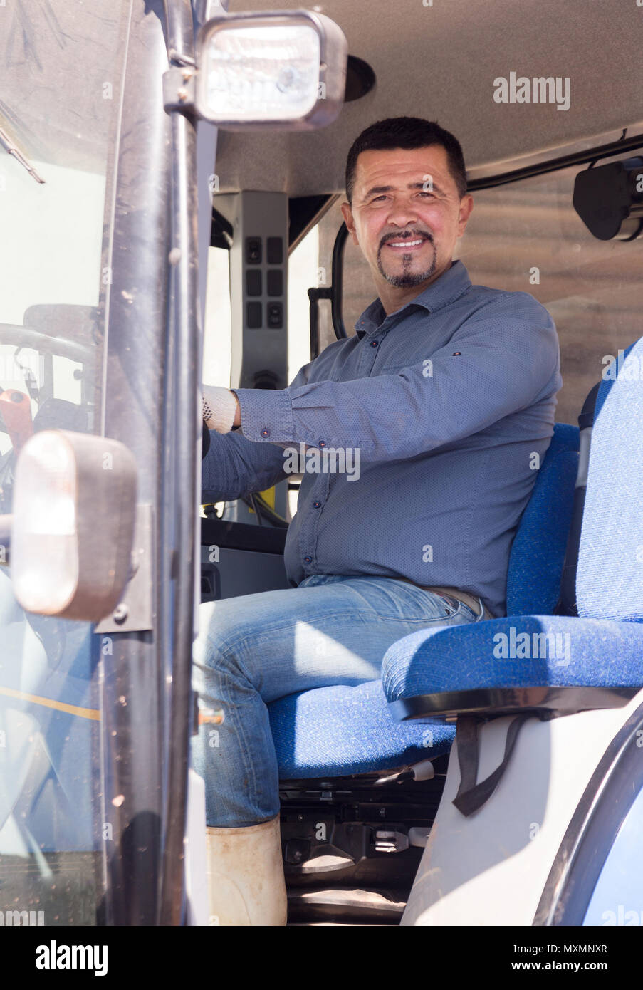 Cheerful farmer sitting in big tractor outdoor on farm Stock Photo - Alamy