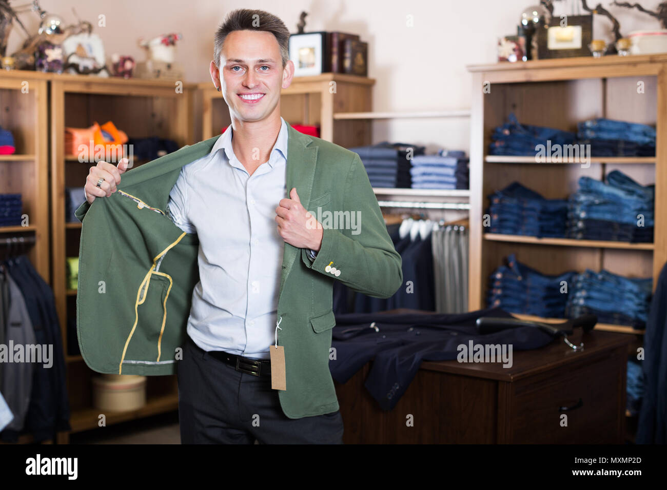 Happy male customer examining suits in male cloths store Stock Photo ...