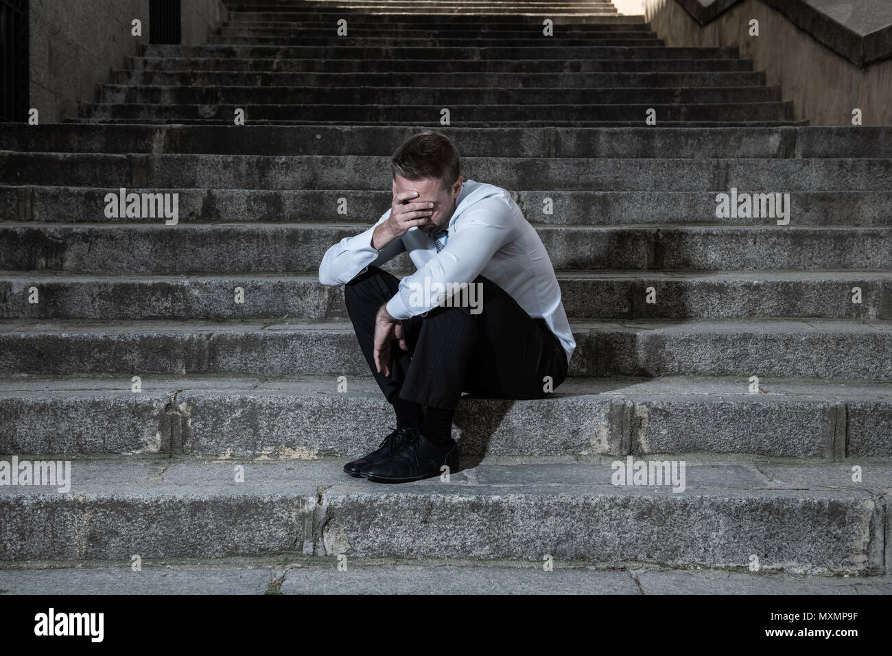 young business man crying abandoned lost in depression sitting on the ...