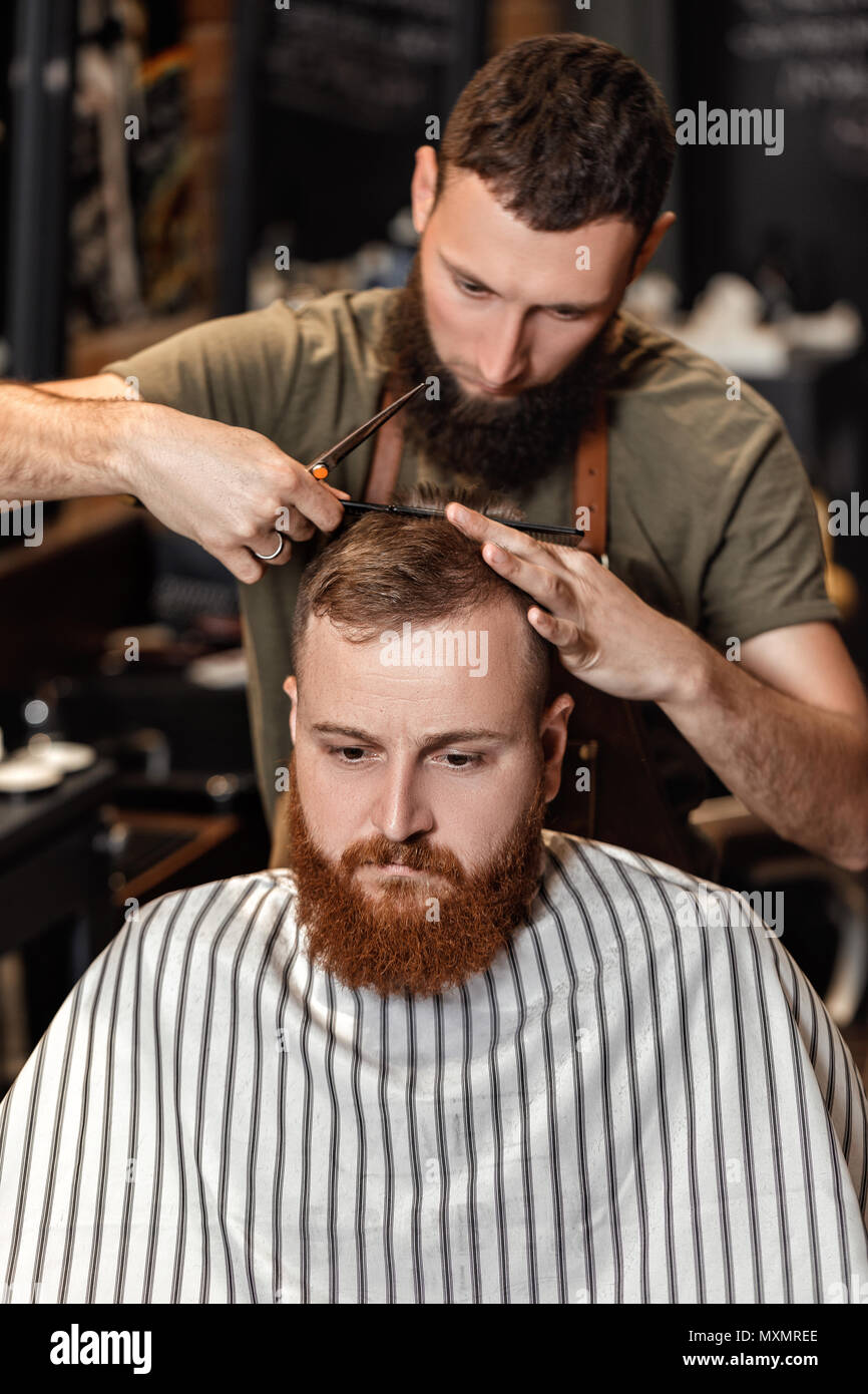 Barber and bearded man in barber shop Stock Photo - Alamy