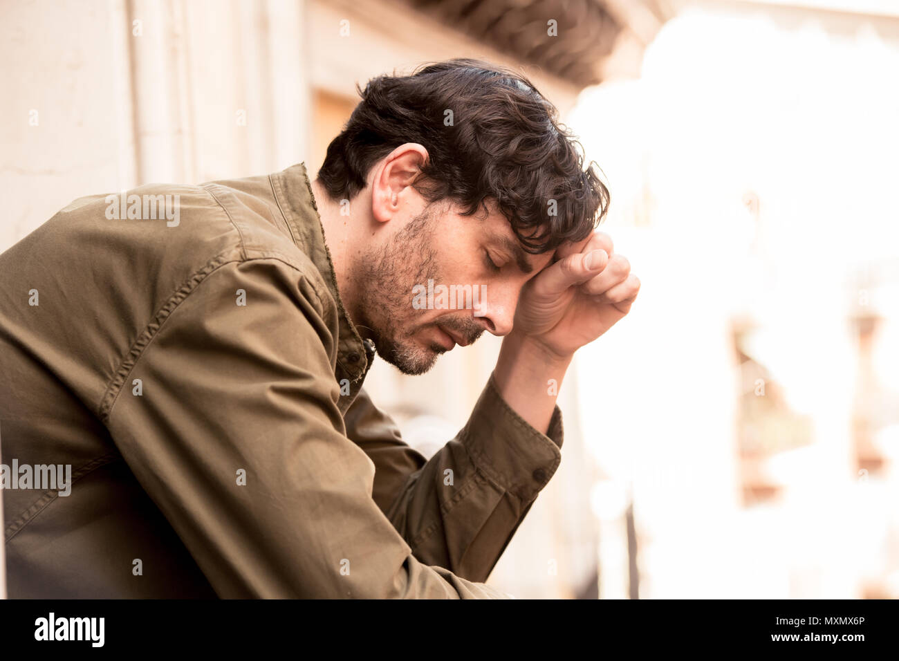 close up portrait of sad and depressed man looking out the window on a ...