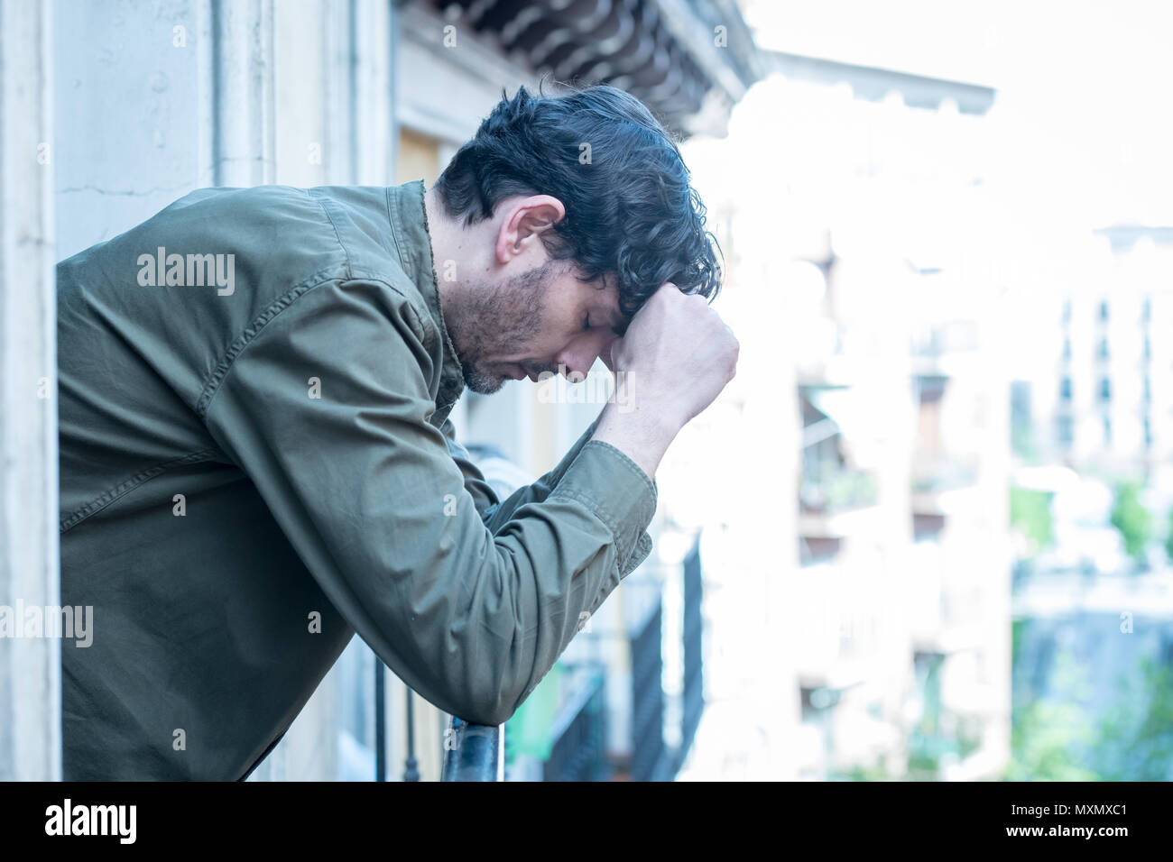 close up portrait of sad and depressed man looking out the window on a ...