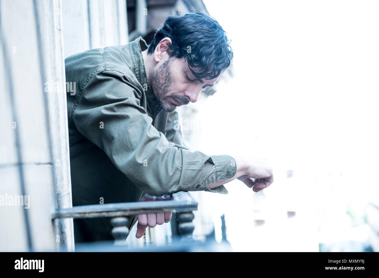 close up portrait of sad and depressed man looking out the window on a ...