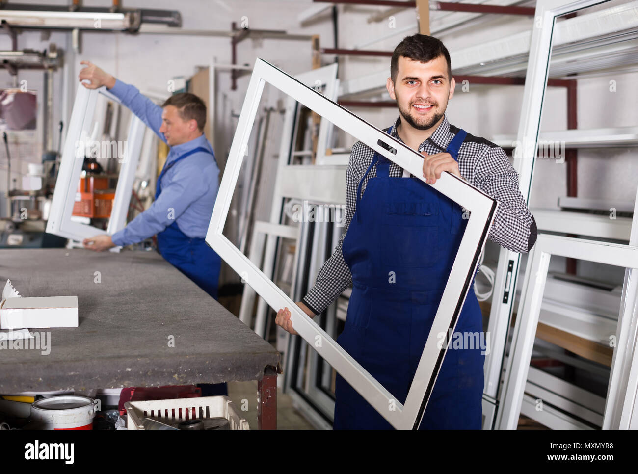Production smiling english workers in coverall with different finished ...