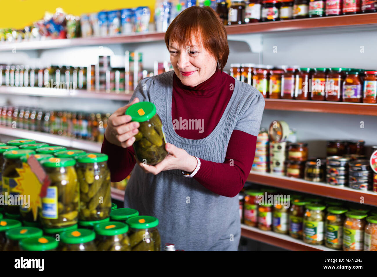 Adult happy cheerful positive smiling female customer holding glass jar ...