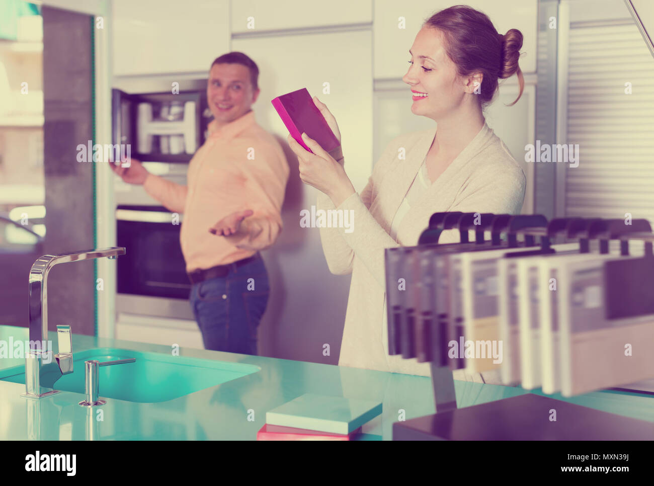 Smiling middle class family selecting modern kitchen furniture Stock ...