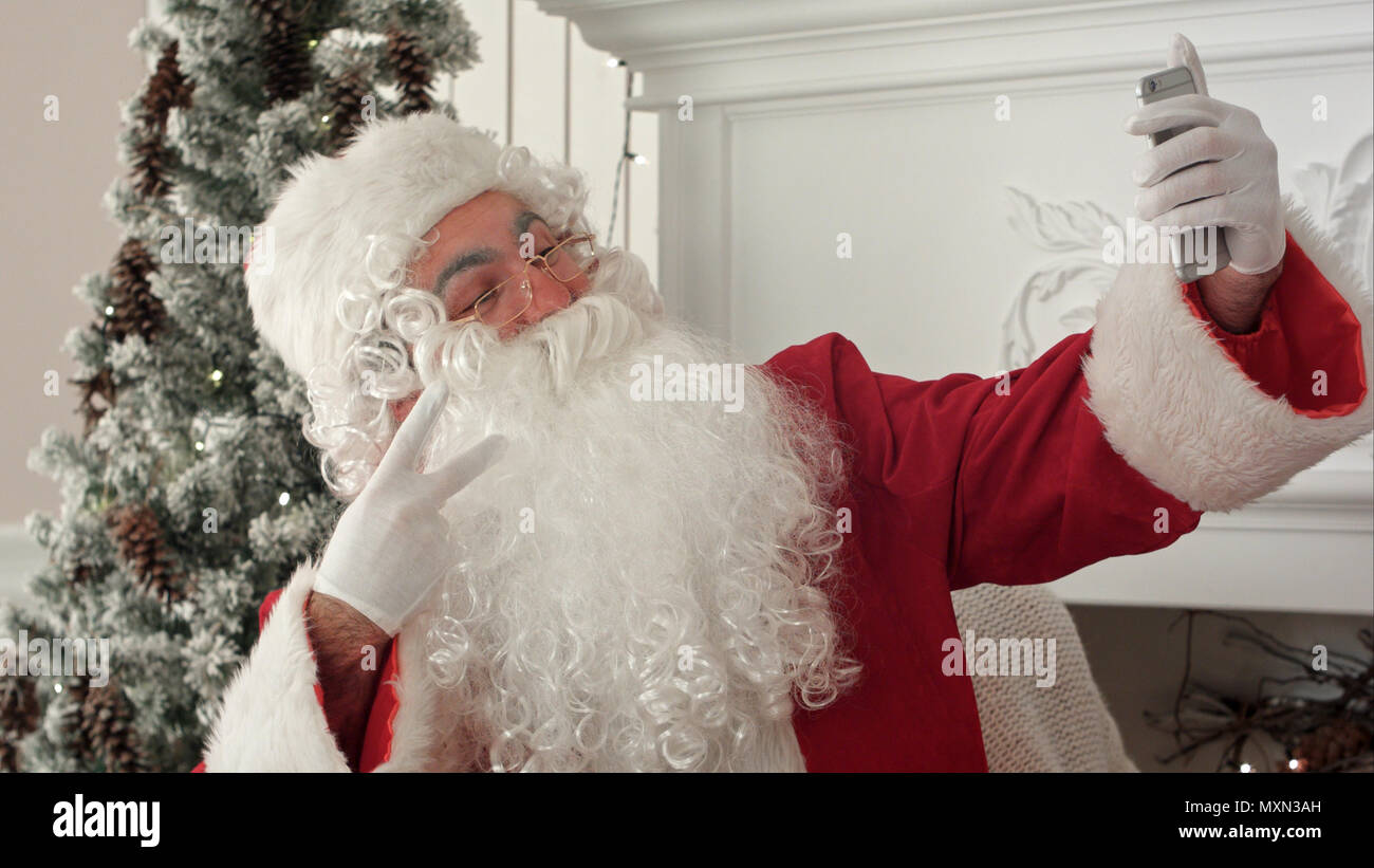 Santa Claus using mobile phone to take Xmas selfies Stock Photo - Alamy
