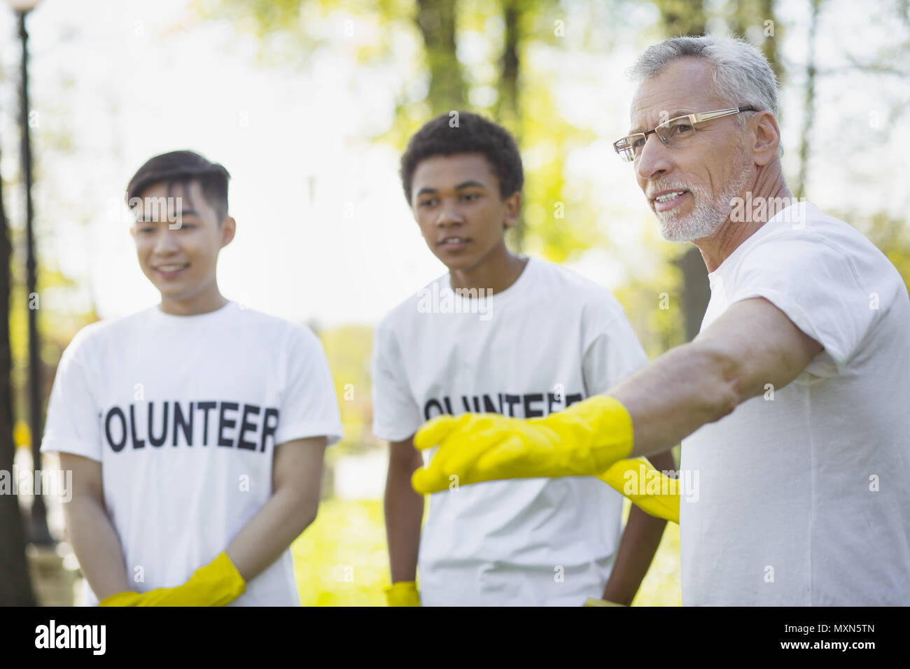 Focused three volunteers discussing plan Stock Photo - Alamy