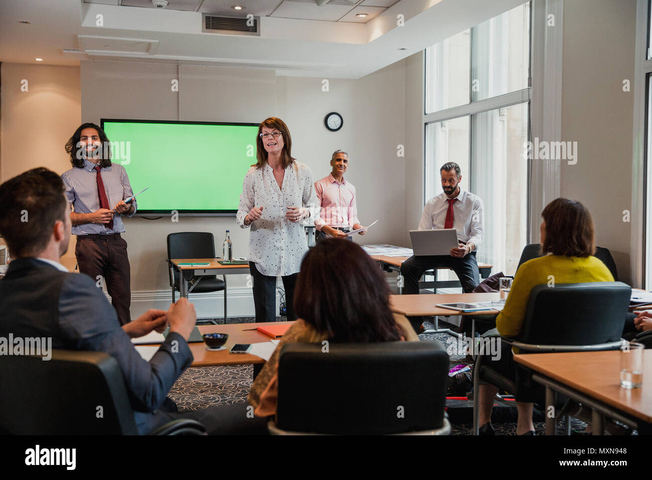 Group of business men and women giving a presentation to another small ...