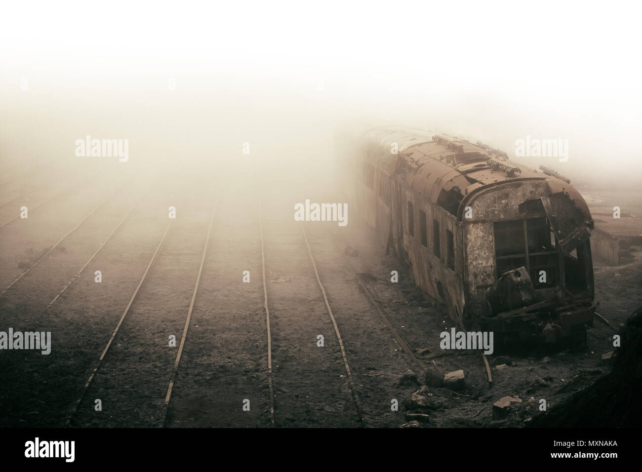 Abandoned rusting train and empty train tracks photographed in misty ...