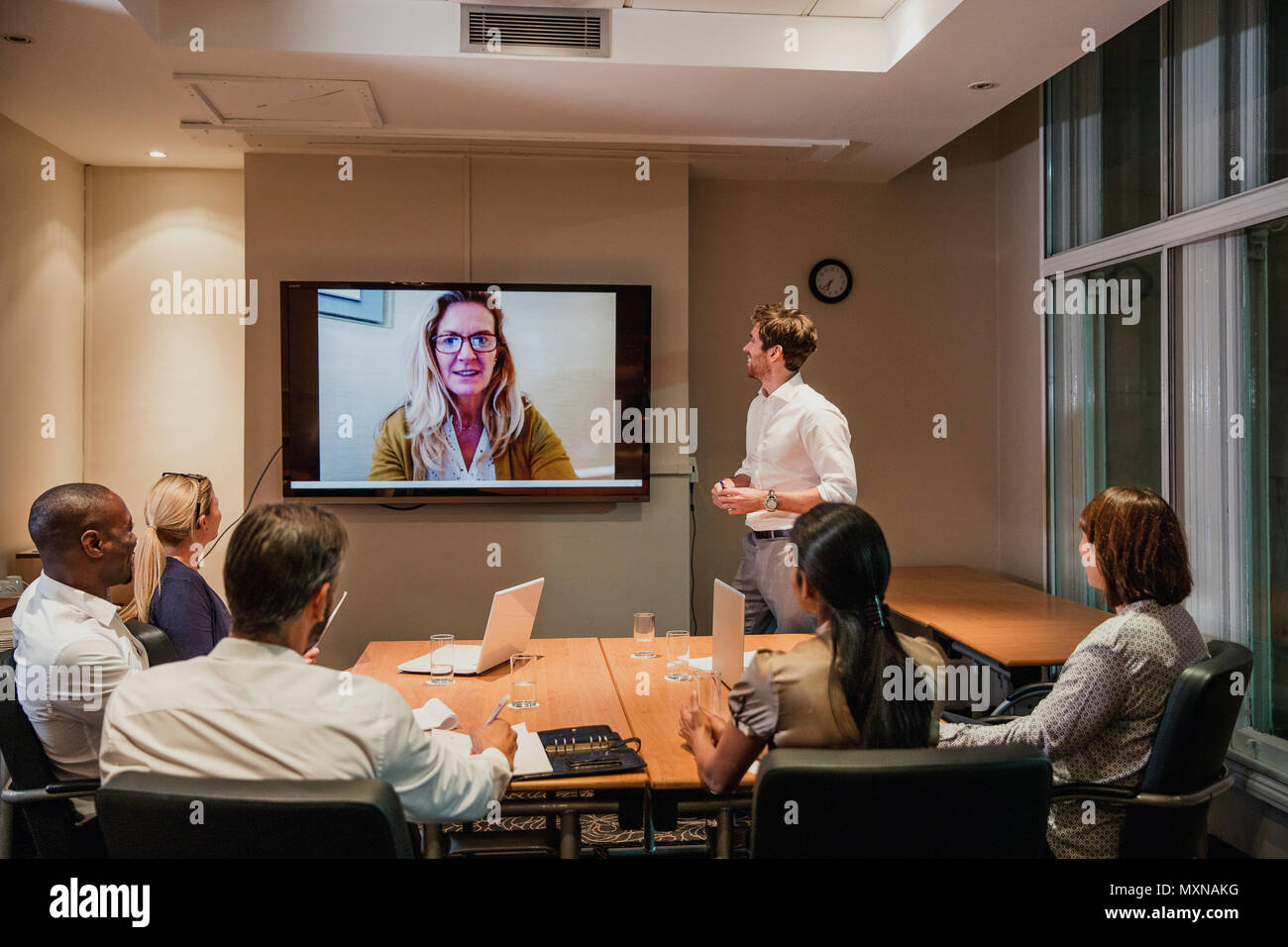 Group of business people having a late night video conference meeting ...