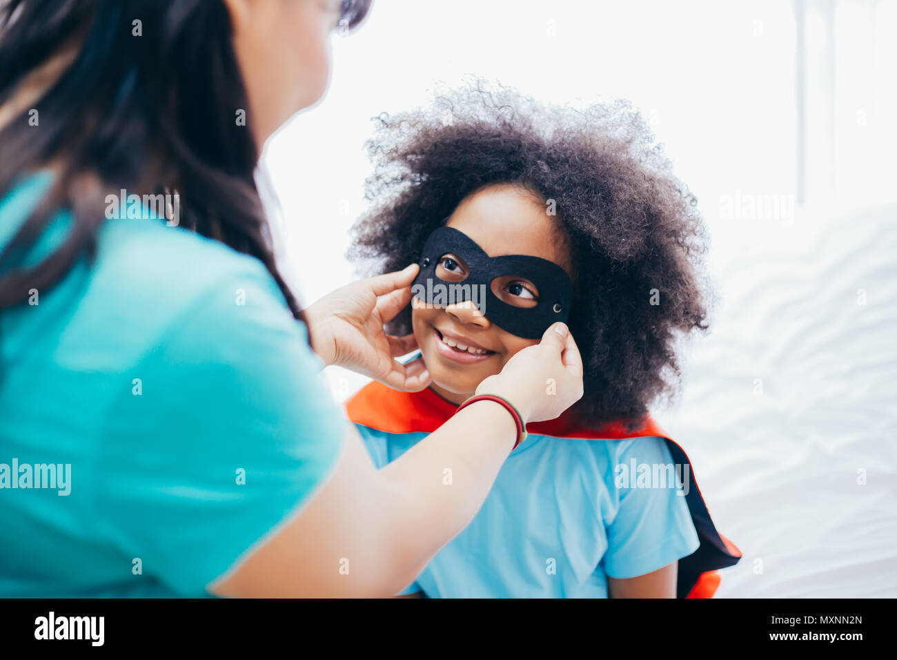 African American kid being supported and helped by supportive mother ...