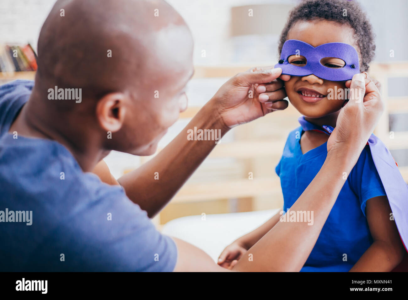 Happy smiling African American son being supported and helped by ...