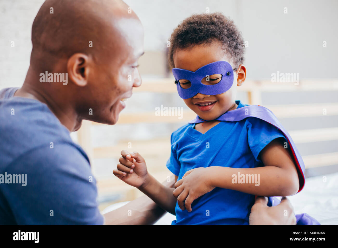 Happy smiling African American son being supported and helped by ...