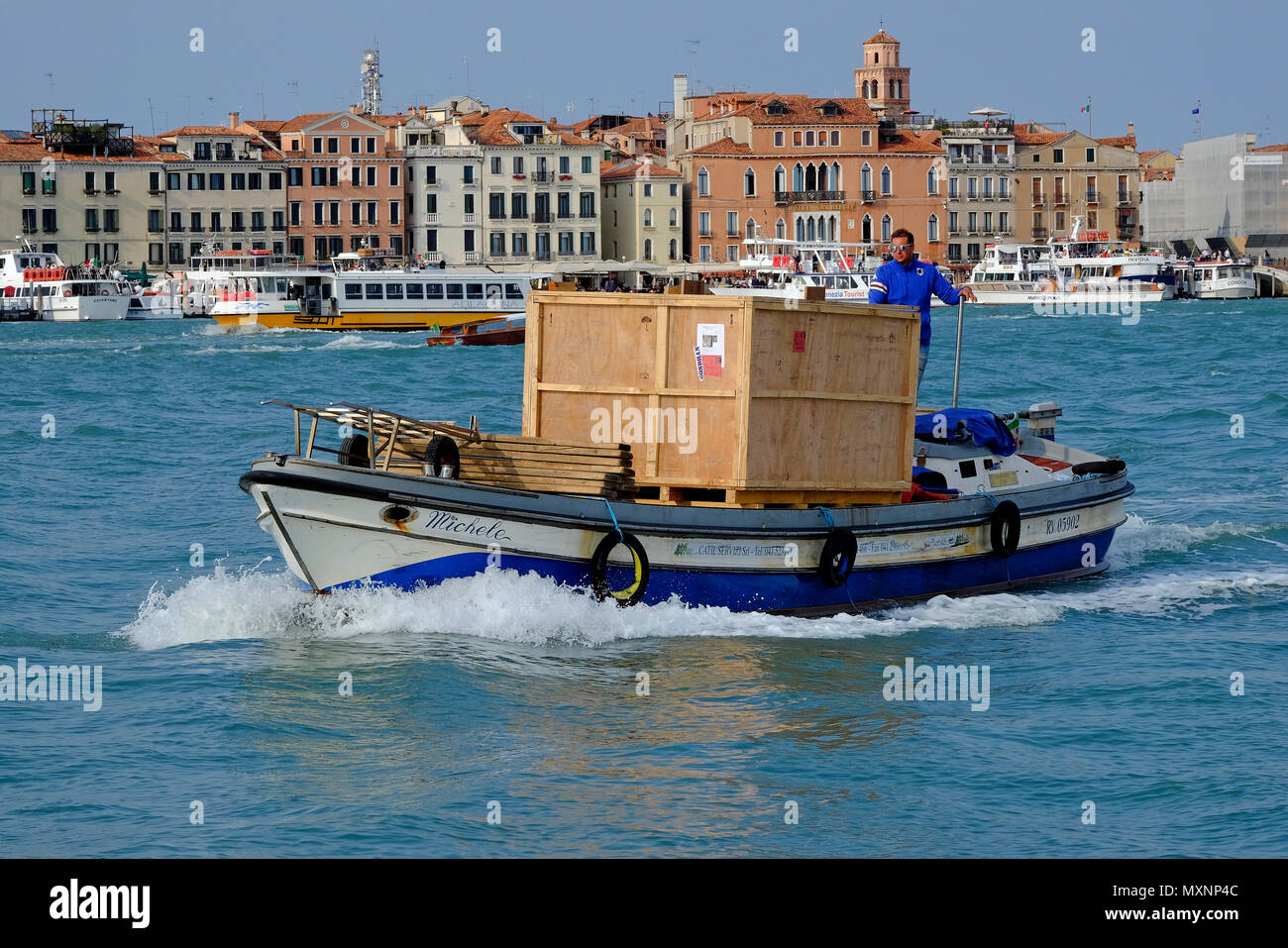 delivery boat carrying large wooden crate, venice, italy Stock Photo ...