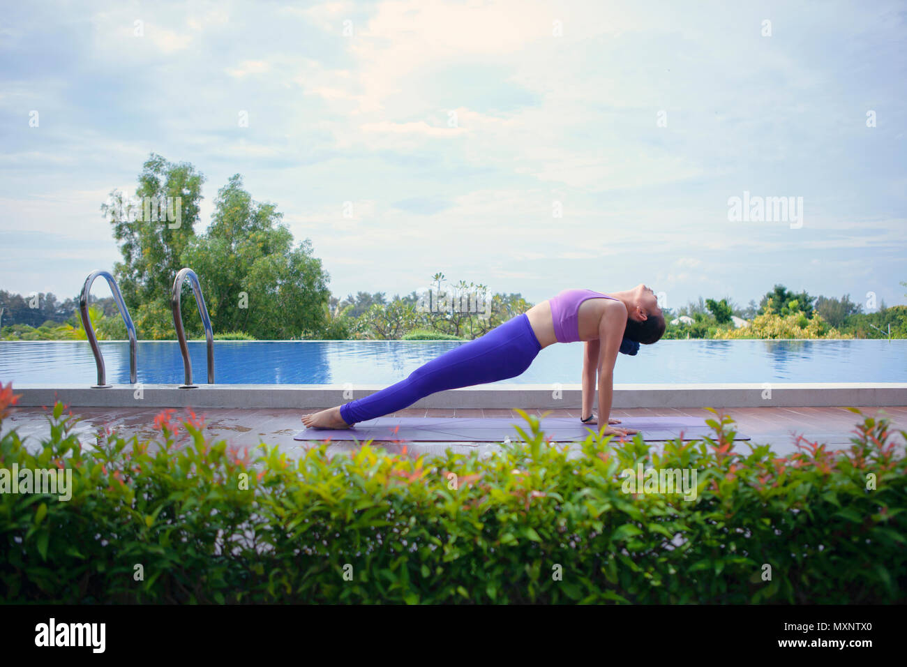 Woman relaxing by the pool yoga pose hi-res stock photography and ...