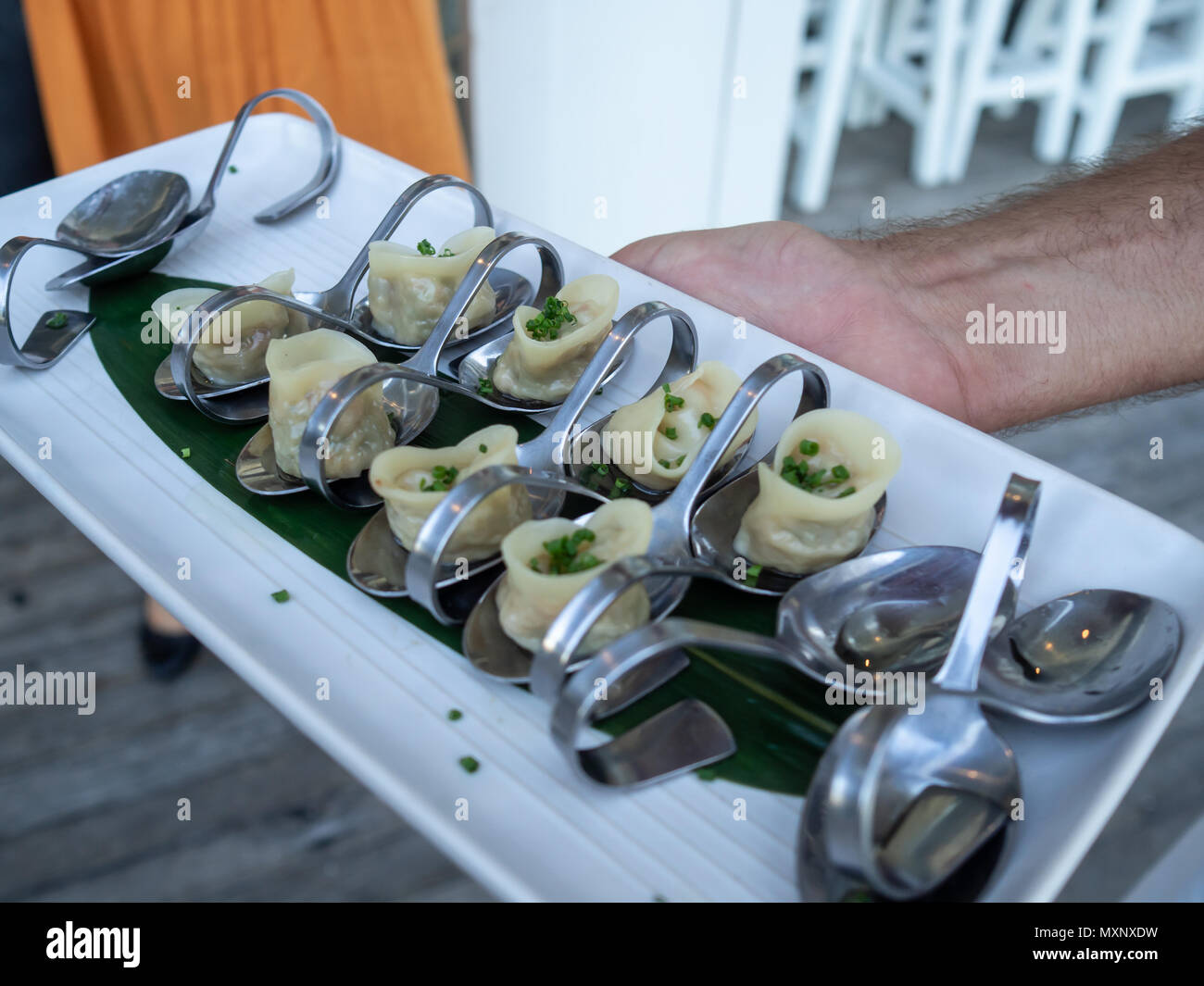 Canapes: seafood dumplings with spring onion served on silver spoons ...