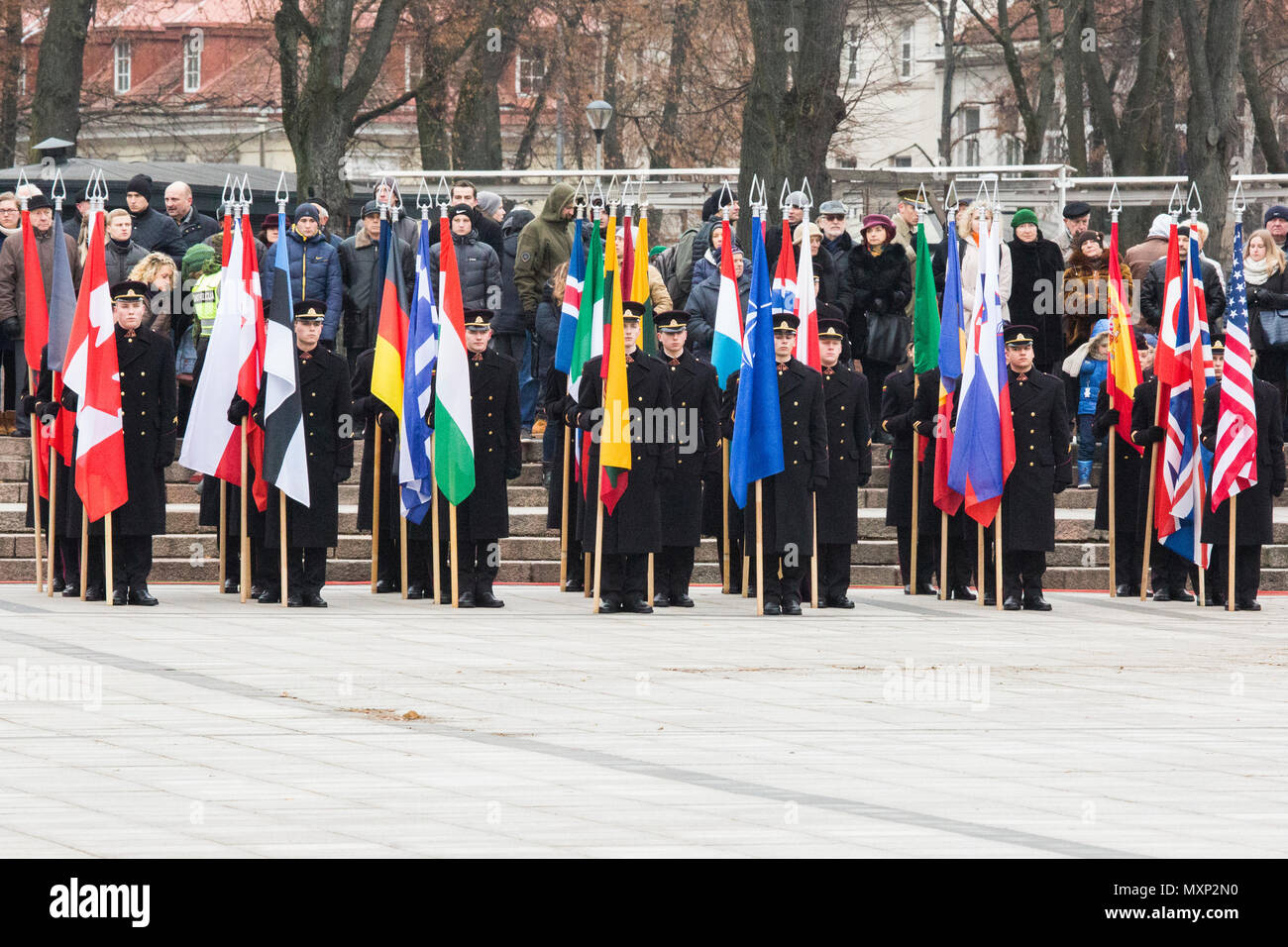 Lithuanian service members hold the flags of other NATO members during ...