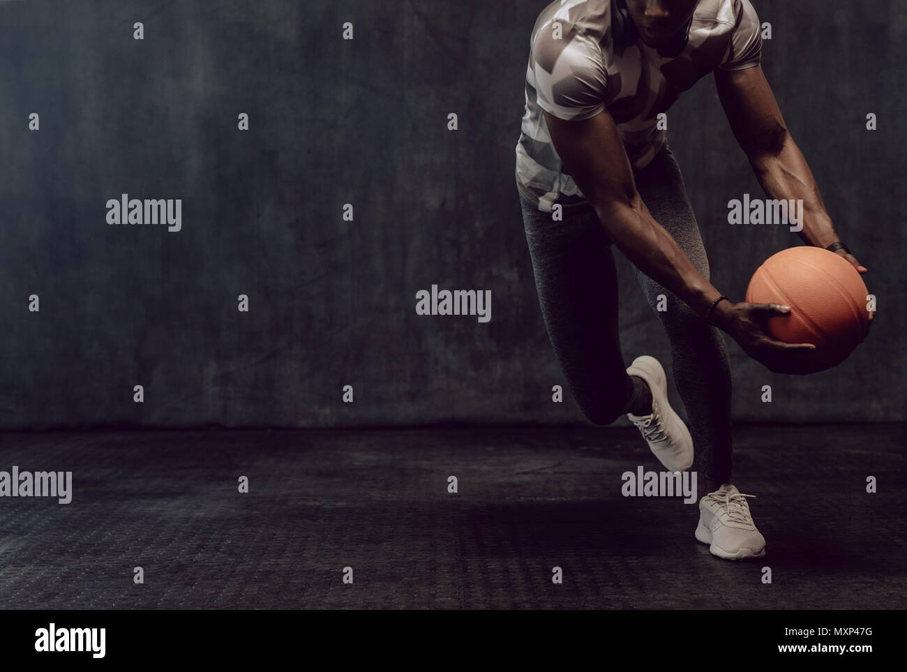 Athletic man training with a basketball. Man working out holding a ...